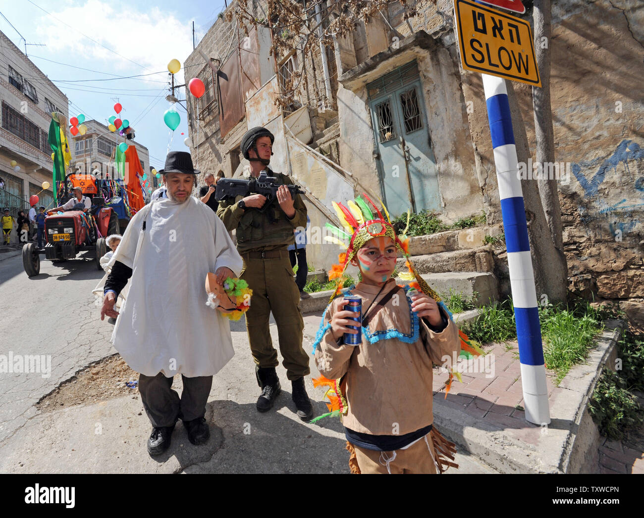 An Israeli soldier guards Jewish settlers, in costumes, during the ...