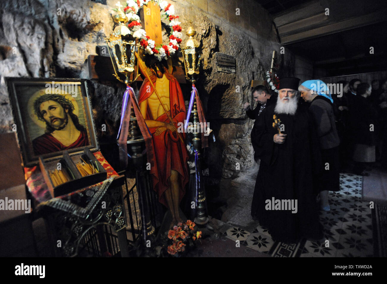 An Orthodox priest carries a cross at a site believed to be the prison ...