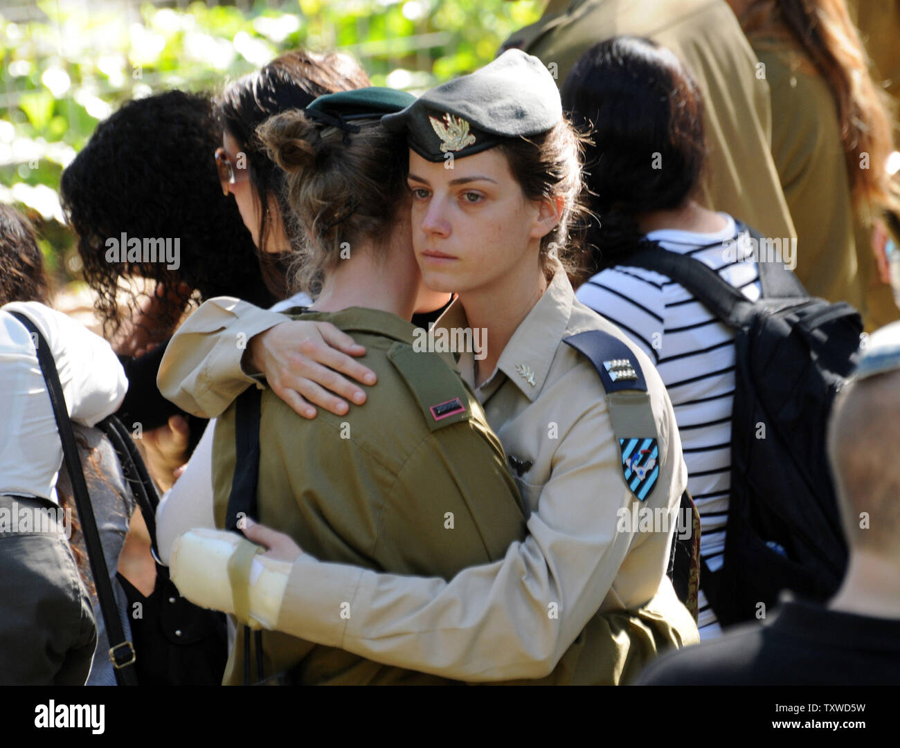 Israeli soldiers hug by the graves of fallen soldiers on Memorial Day ...
