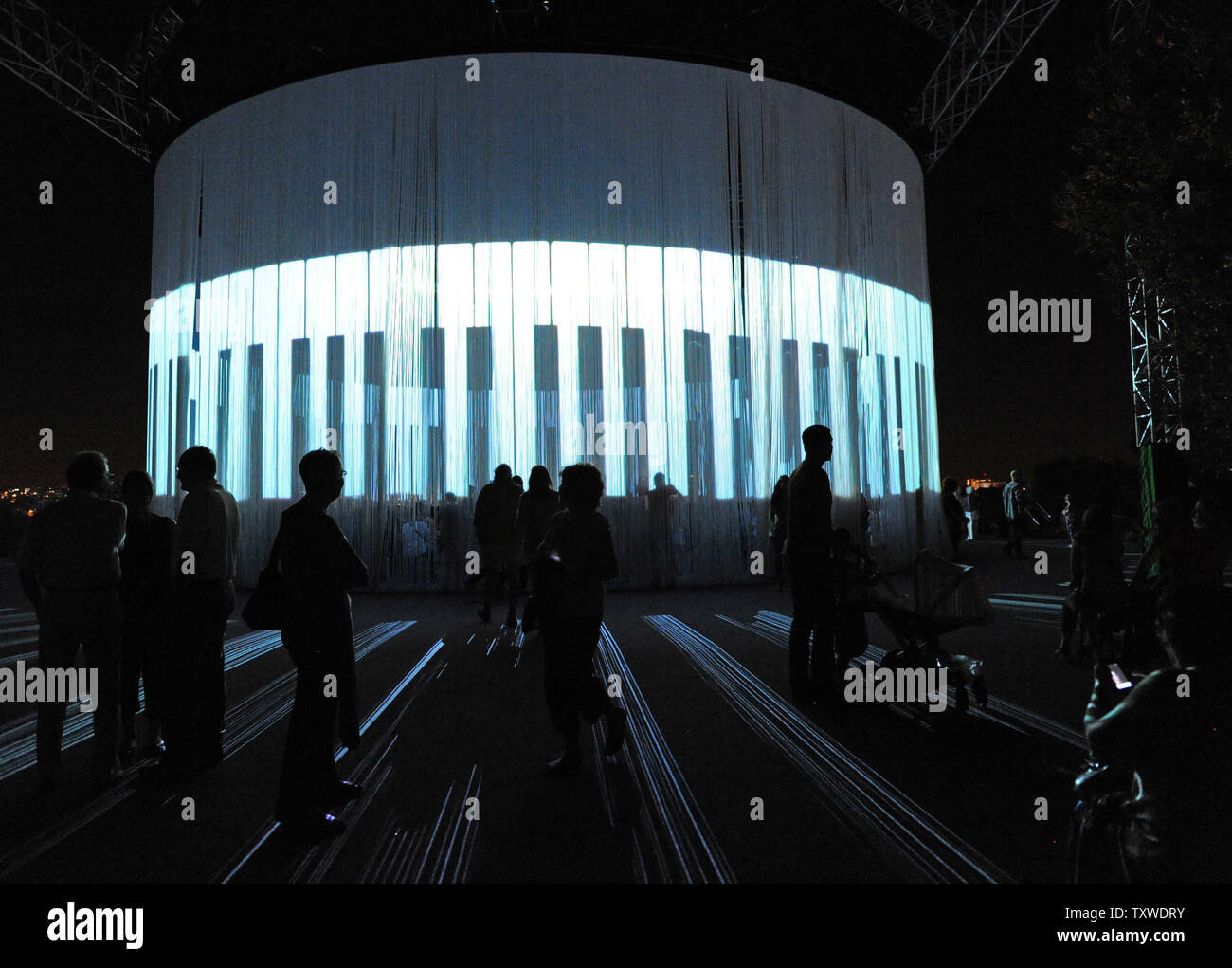 Visitors watch videos on a monumental installation by Israeli designer ...