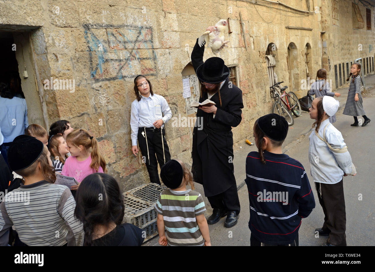 An Ultra-Orthodox Jewish man swings a chicken over his head during the ...