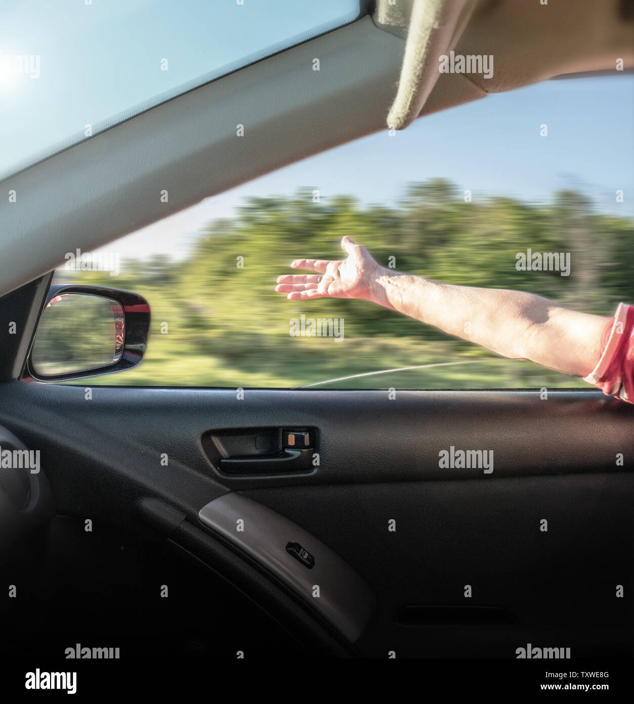 She is sticking her hand out the car window Stock Photo - Alamy