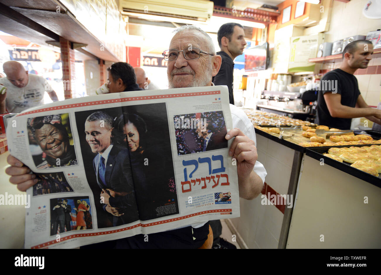 An Israeli man holds up a Hebrew newspaper with photos of US President ...