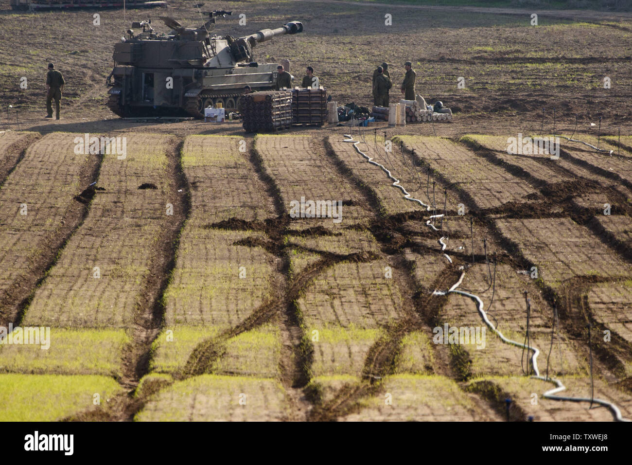 An Israeli army artillery piece is positioned in an agricultural field ...
