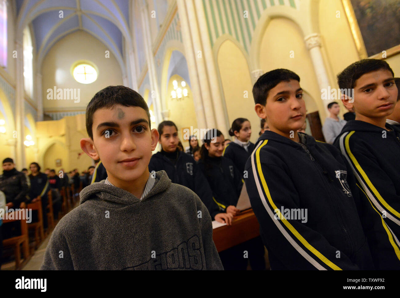 Palestinian Catholic boys with ashes on the foreheads worship during an ...