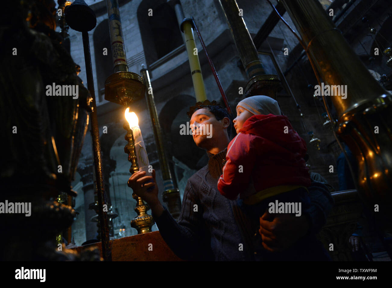 A Christian pilgrim lights candles in the Church of the Holy Sepulchre ...