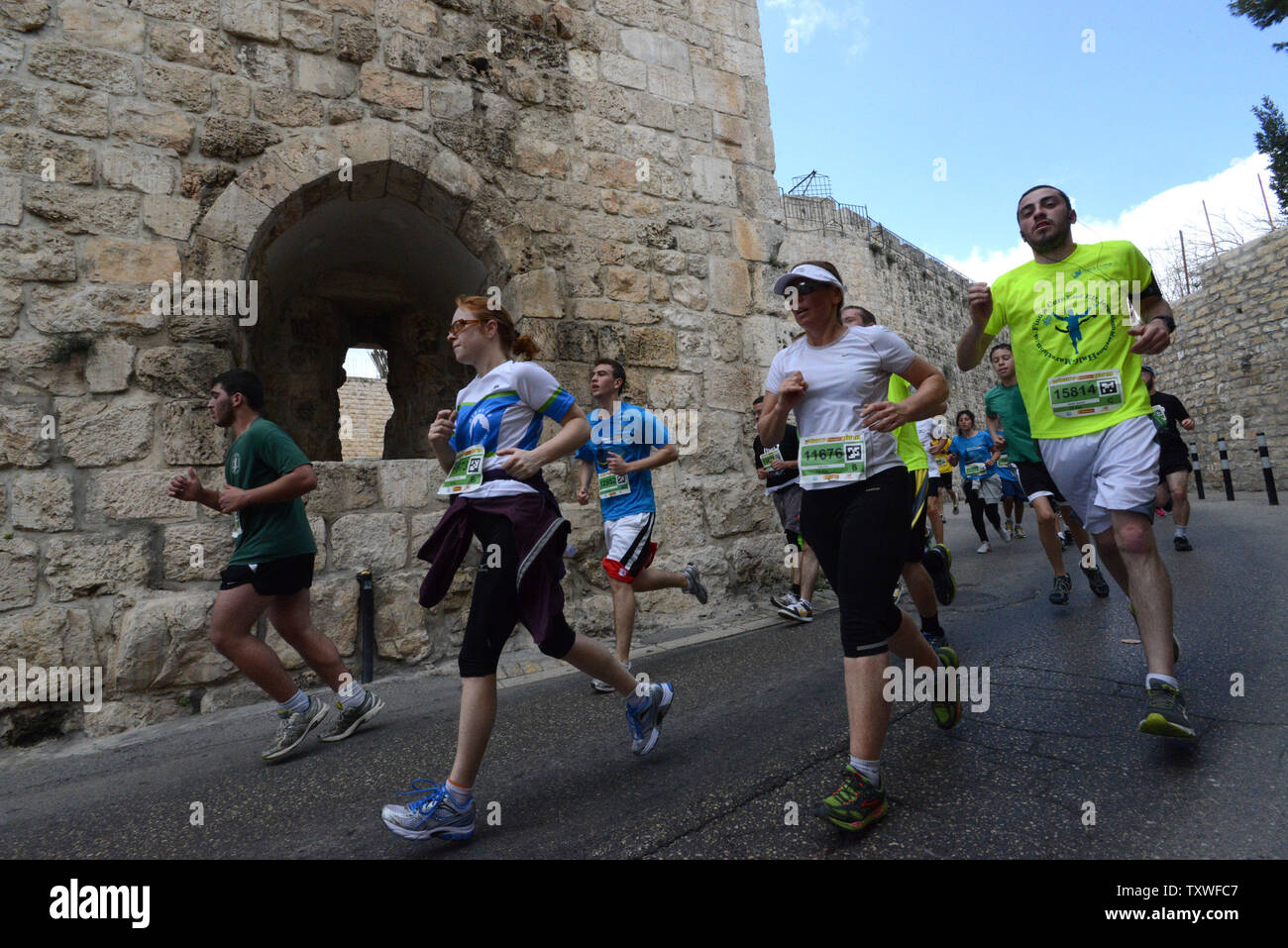 Marathon runners race in the Old City of Jerusalem, Israel, during the ...