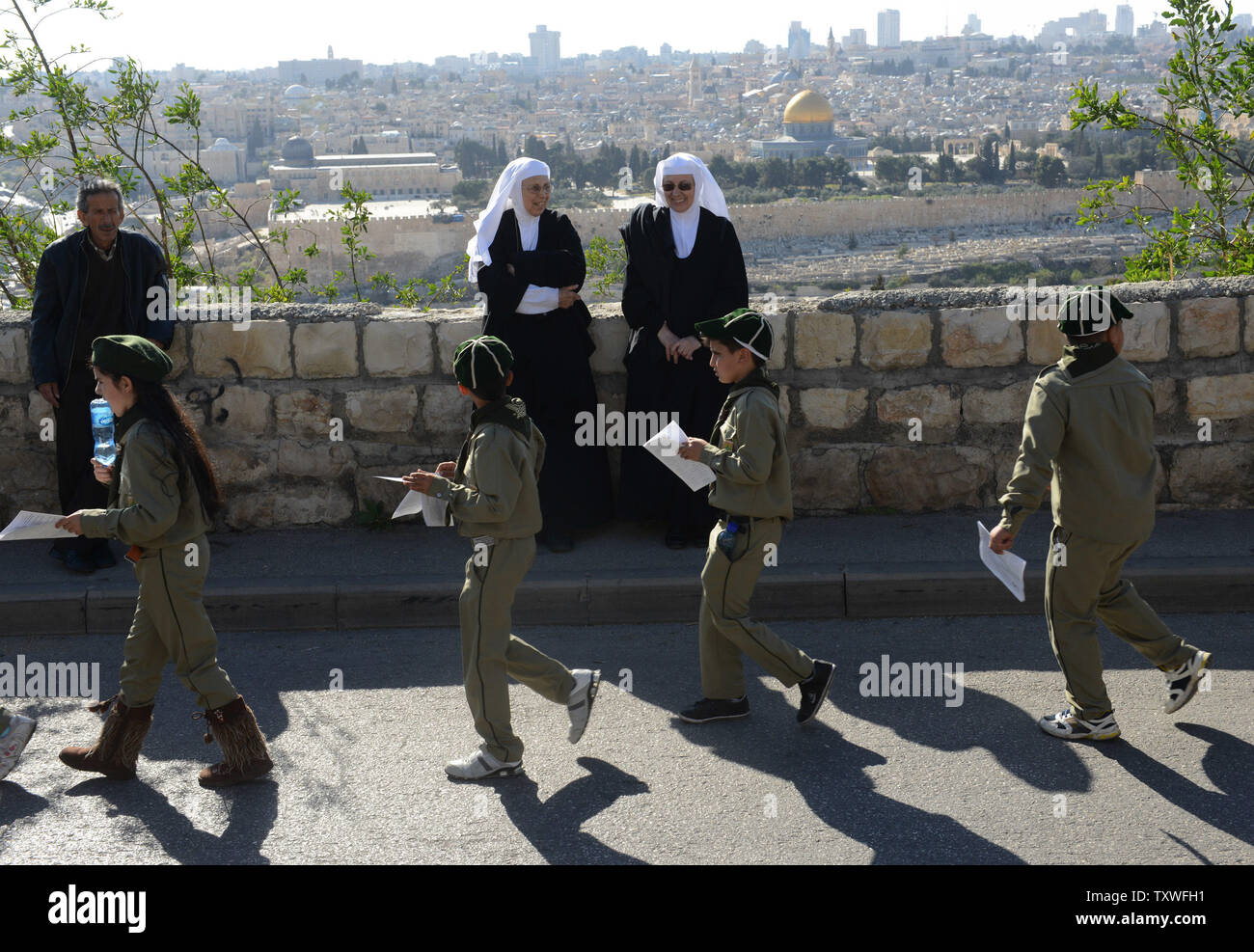 Palestinian Catholic scouts walk past nuns during the traditional Palm ...