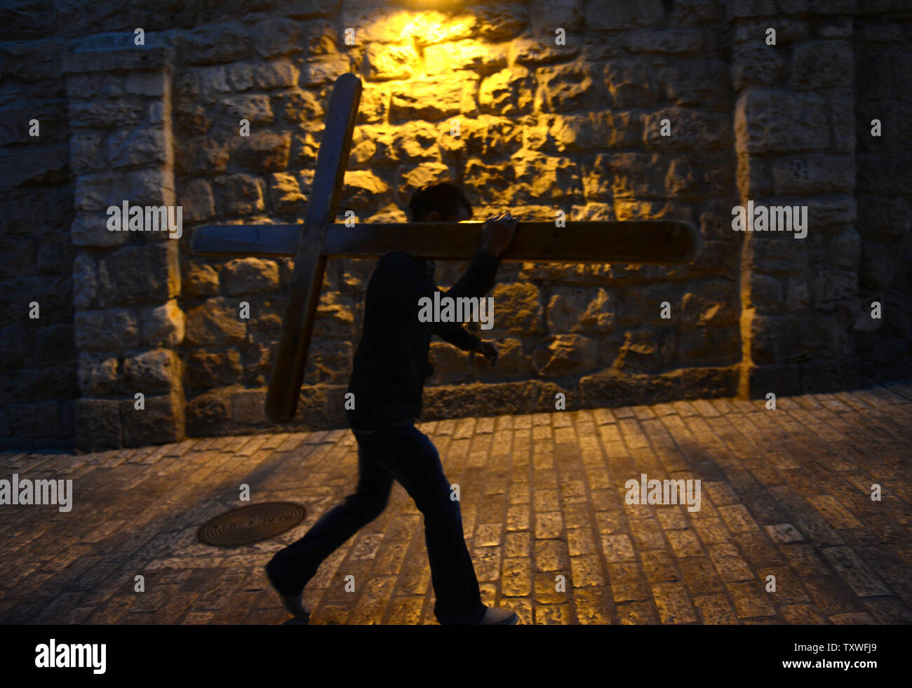 A Palestinian carries a cross at dawn on the Via Dolorosa, The Way of ...