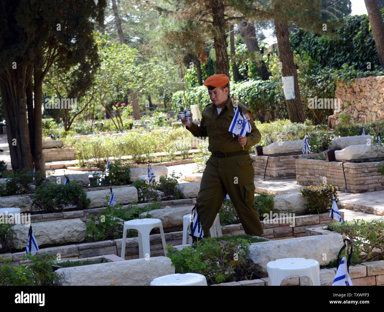 An Israeli soldier carries memorial candles and national flags with ...