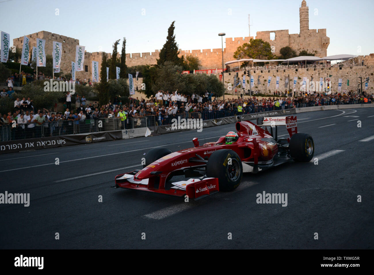 A Ferrari Formula One race car speeds past Israeli spectators below the ...