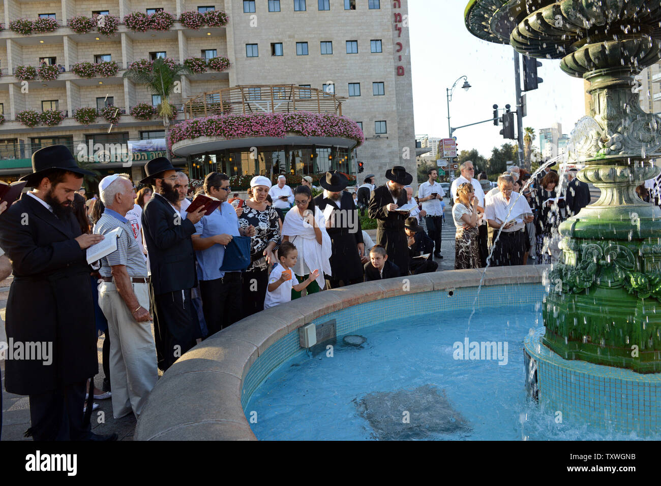Jews read prayers and perform the 'Tashlich' ceremony, by a fountain in ...