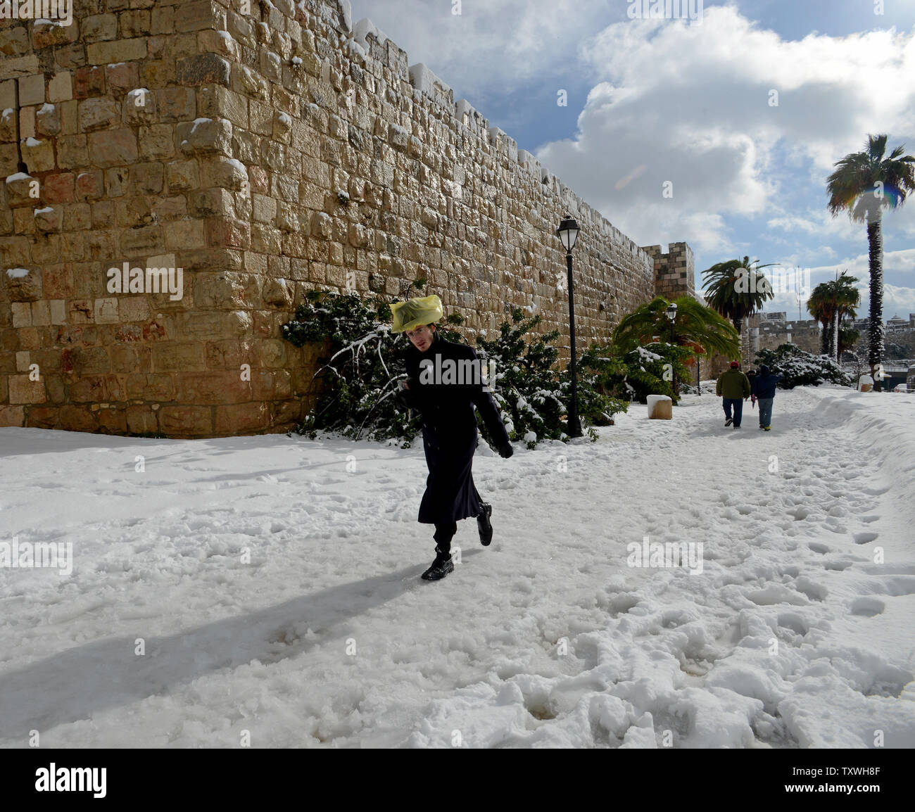An Ultra-Orthodox Israeli walks in the snow outside the Old City of ...