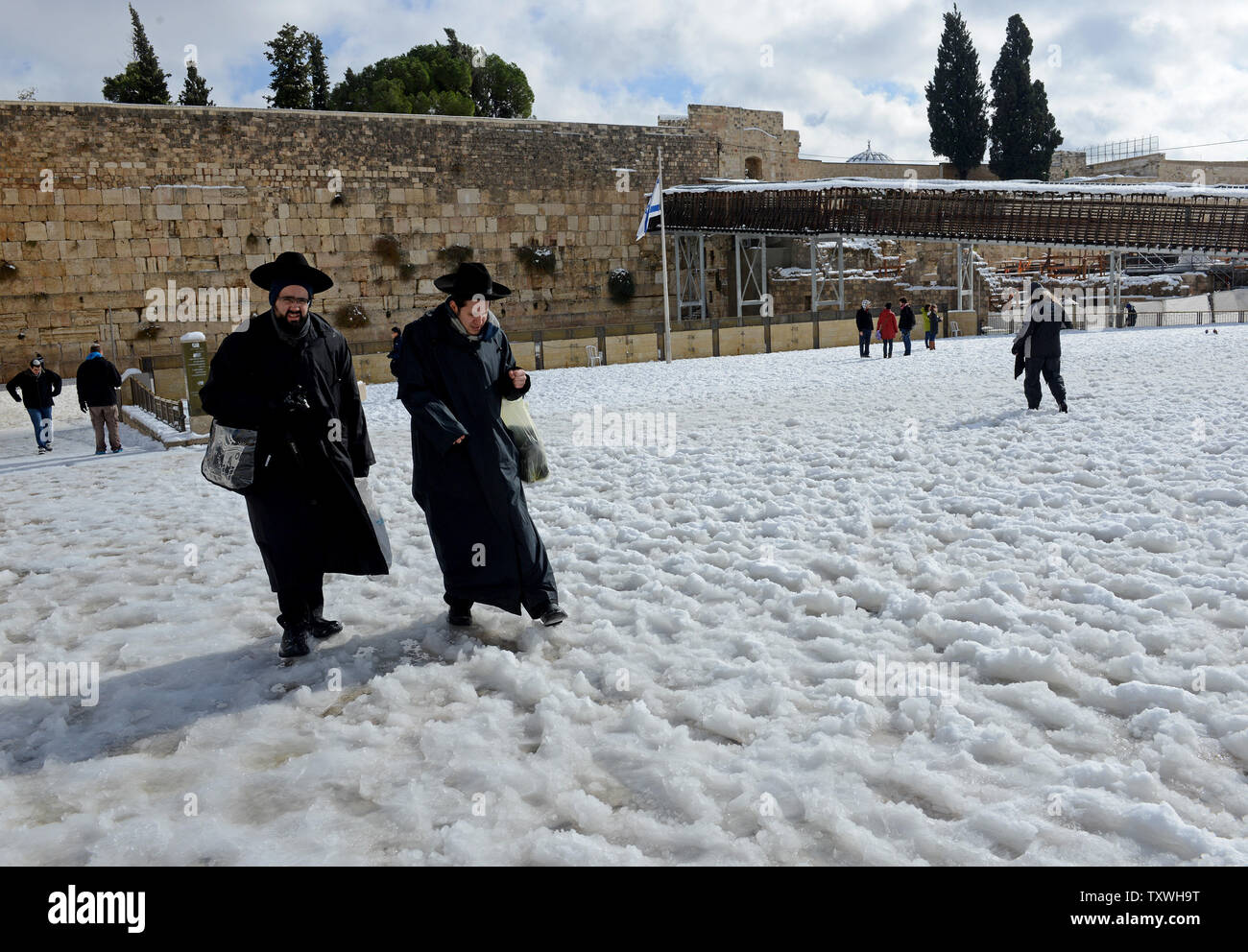 Ultra-Orthodox Israeli Jews walk in the snow at the Western Wall ...
