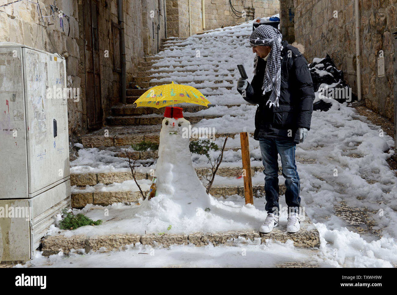 A Palestinian takes a photo with his cellphone of a snowman in the ...