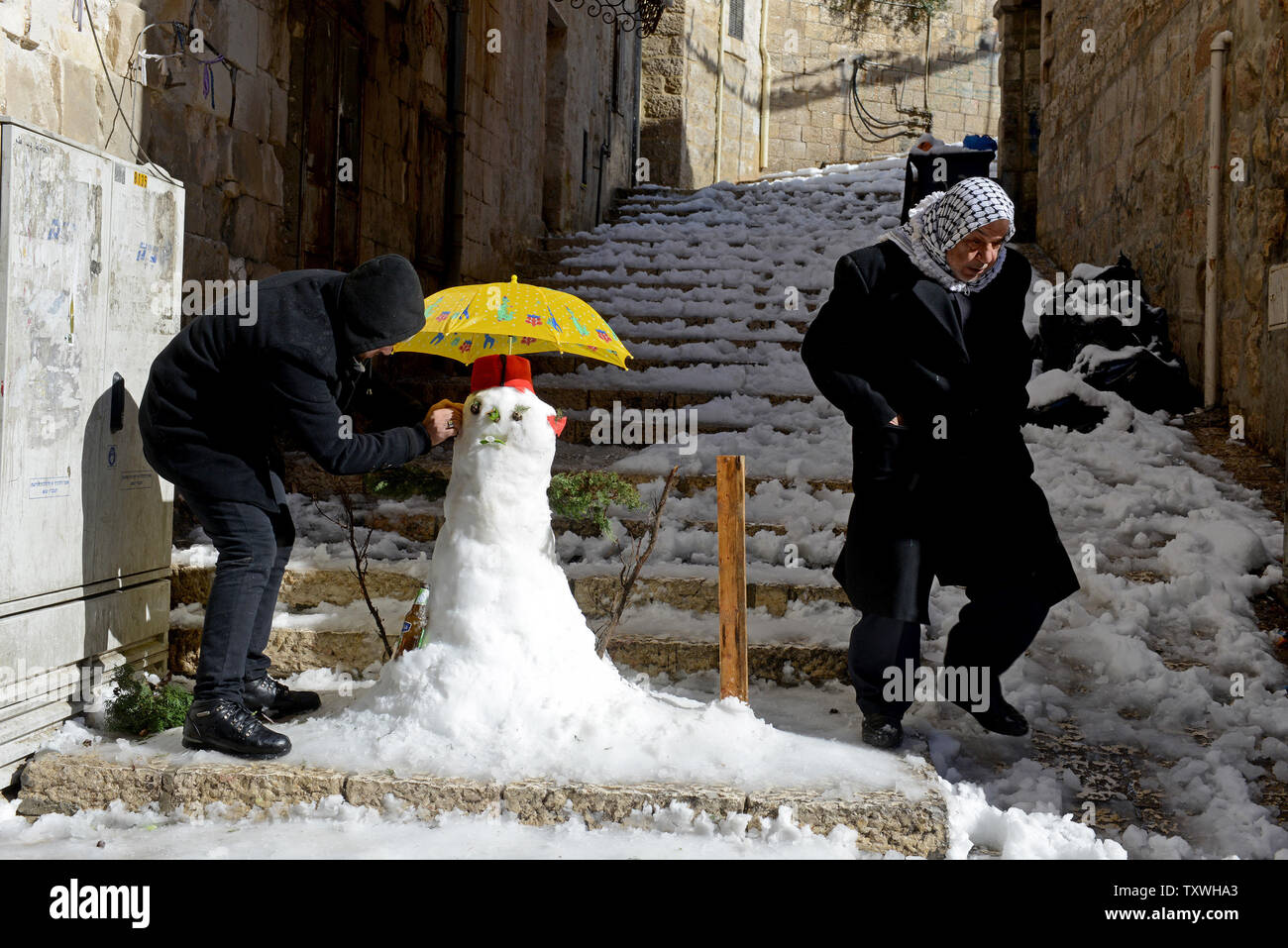 A Palestinian builds a snowman in the Muslim Quarter of the Old City of ...