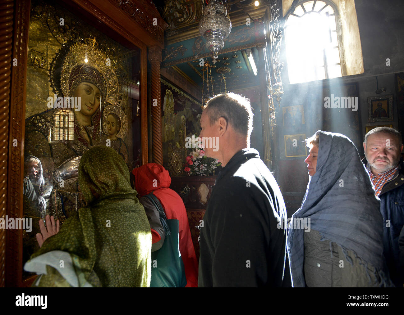 Russian pilgrims pray in front of an icon of the Virgin Mary and baby ...