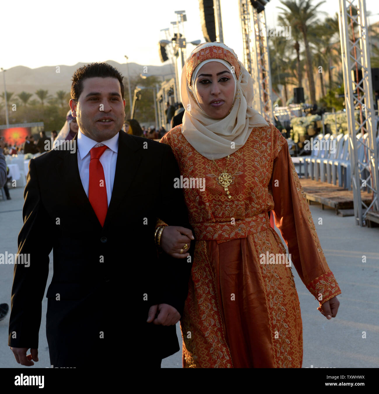 A Palestinian bride and groom walk before getting married in a mass ...