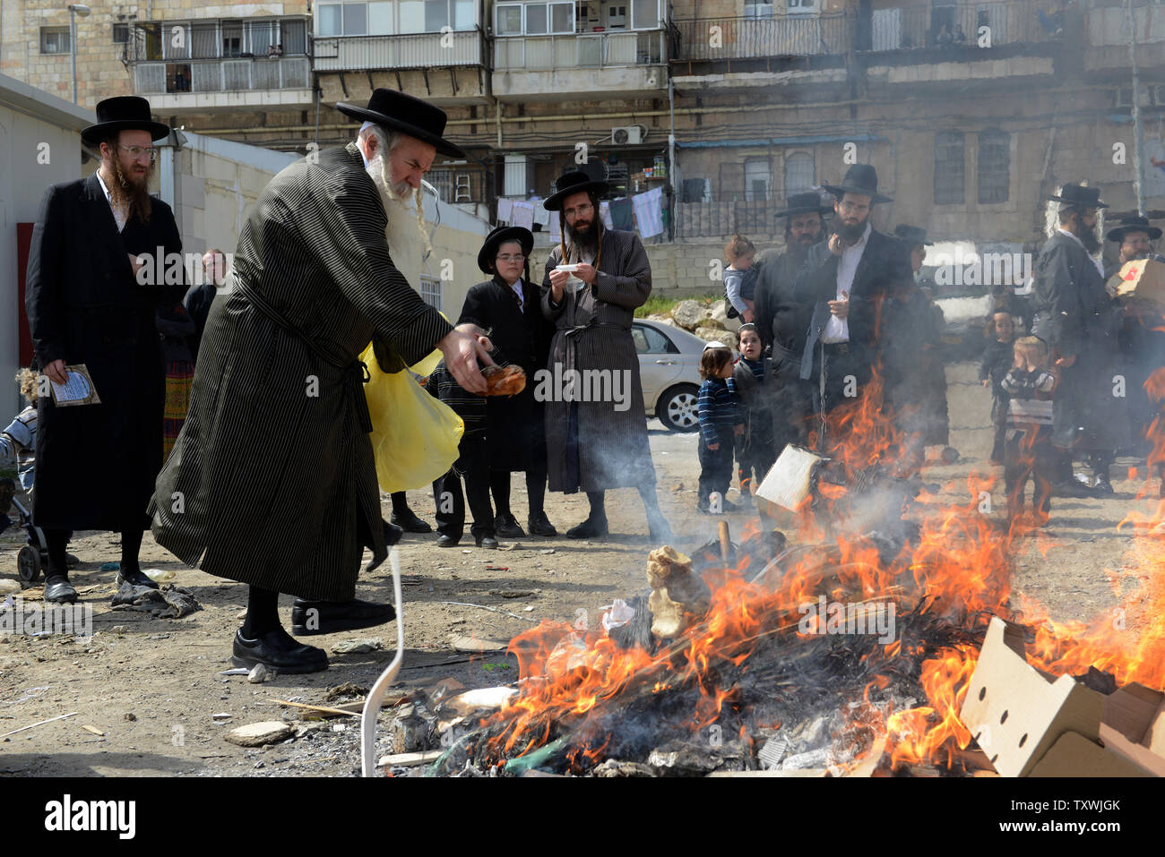 An Ultra Orthodox Jewish man throws bread into the fire before the ...