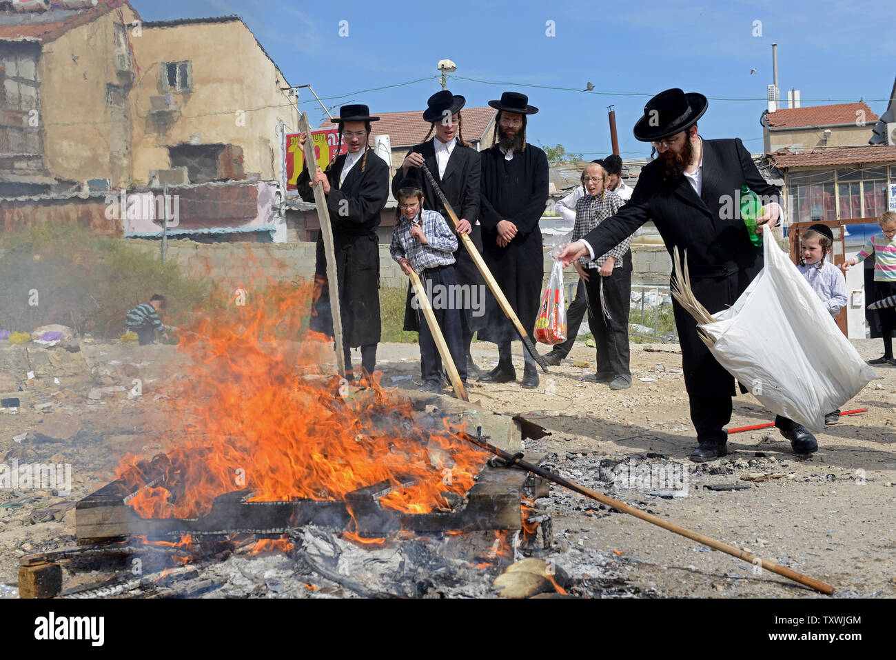 An Ultra Orthodox Jewish man throws a bag of bread in the fire before ...