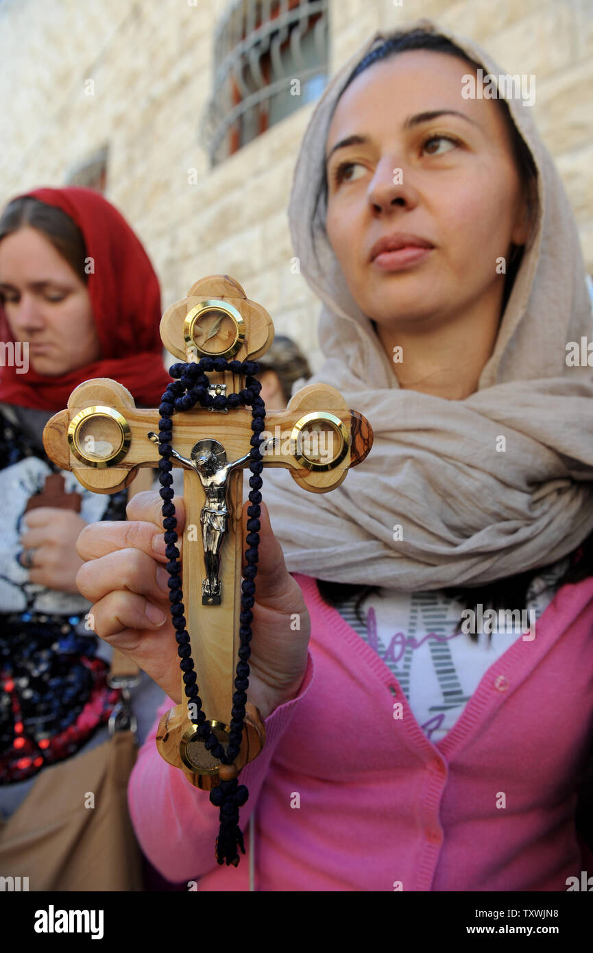 A Christian woman holds a crucifix on Good Friday on the Via Dolorosa ...