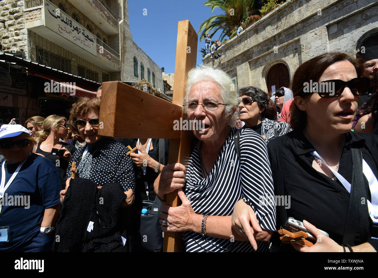 An elderly Christian woman carries a cross on Good Friday on the Via ...