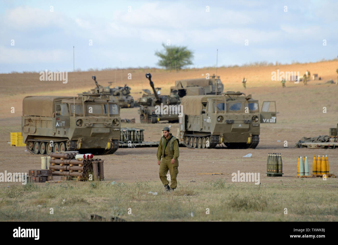 An Israeli soldier walks by artillery shells in a field near Sderot in ...