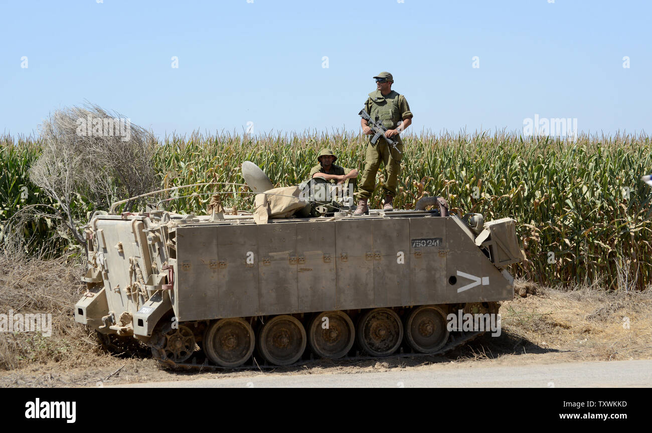 An Israeli soldier guards on an armored personnel carrier at a staging ...