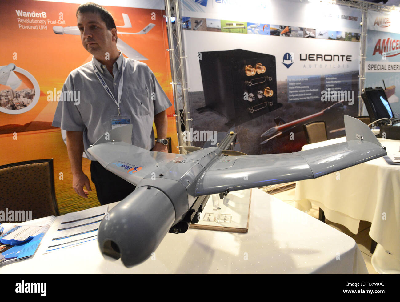 A salesman stands by an unmanned aerial vehicle (UAV) made by the ...