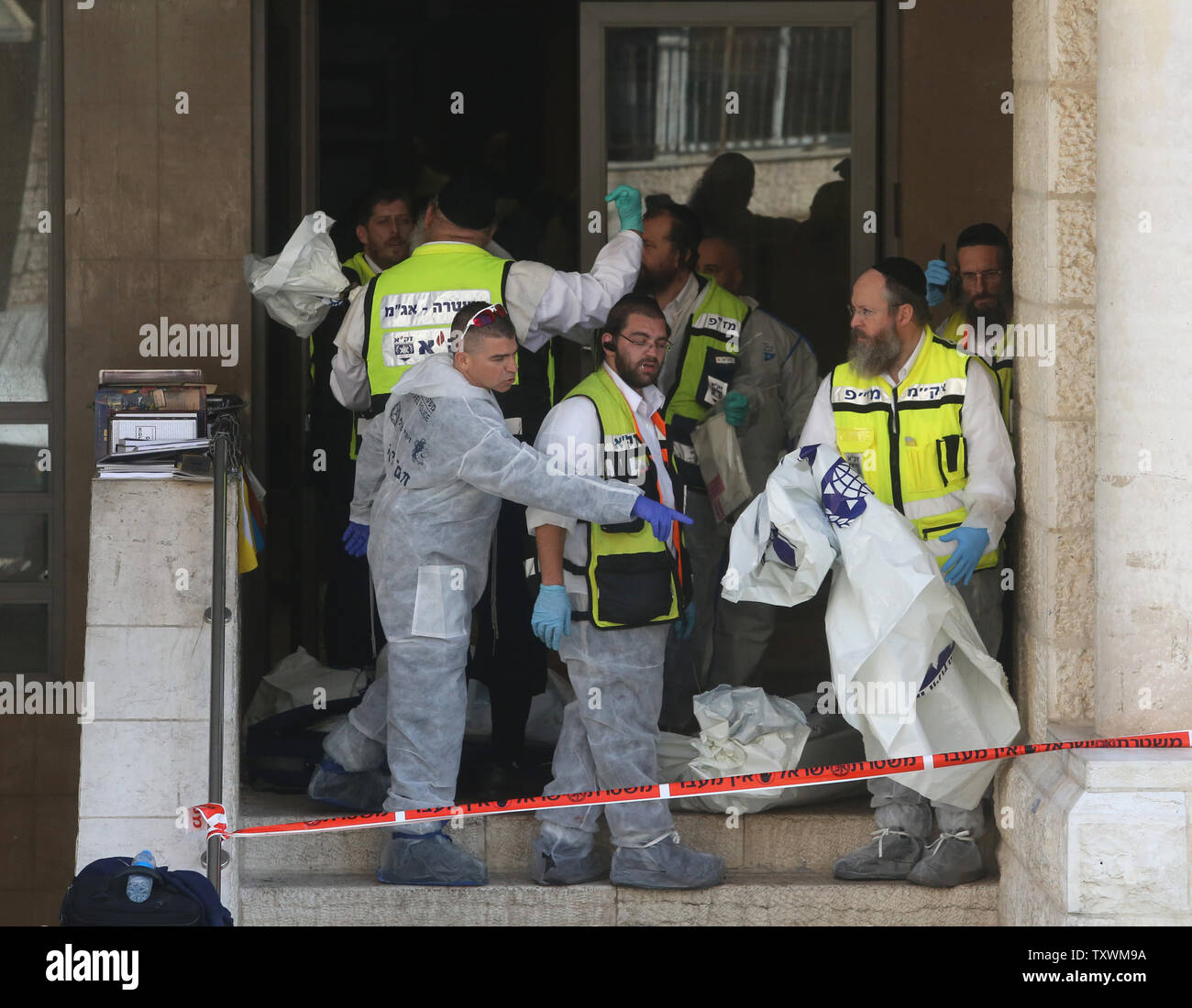 Israeli rescue workers hold body bags at the entrance of a synagogue in ...