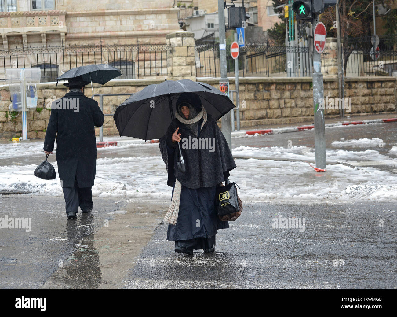 Ultra-Orthodox Jews walk in snow and rain during a winter storm in ...