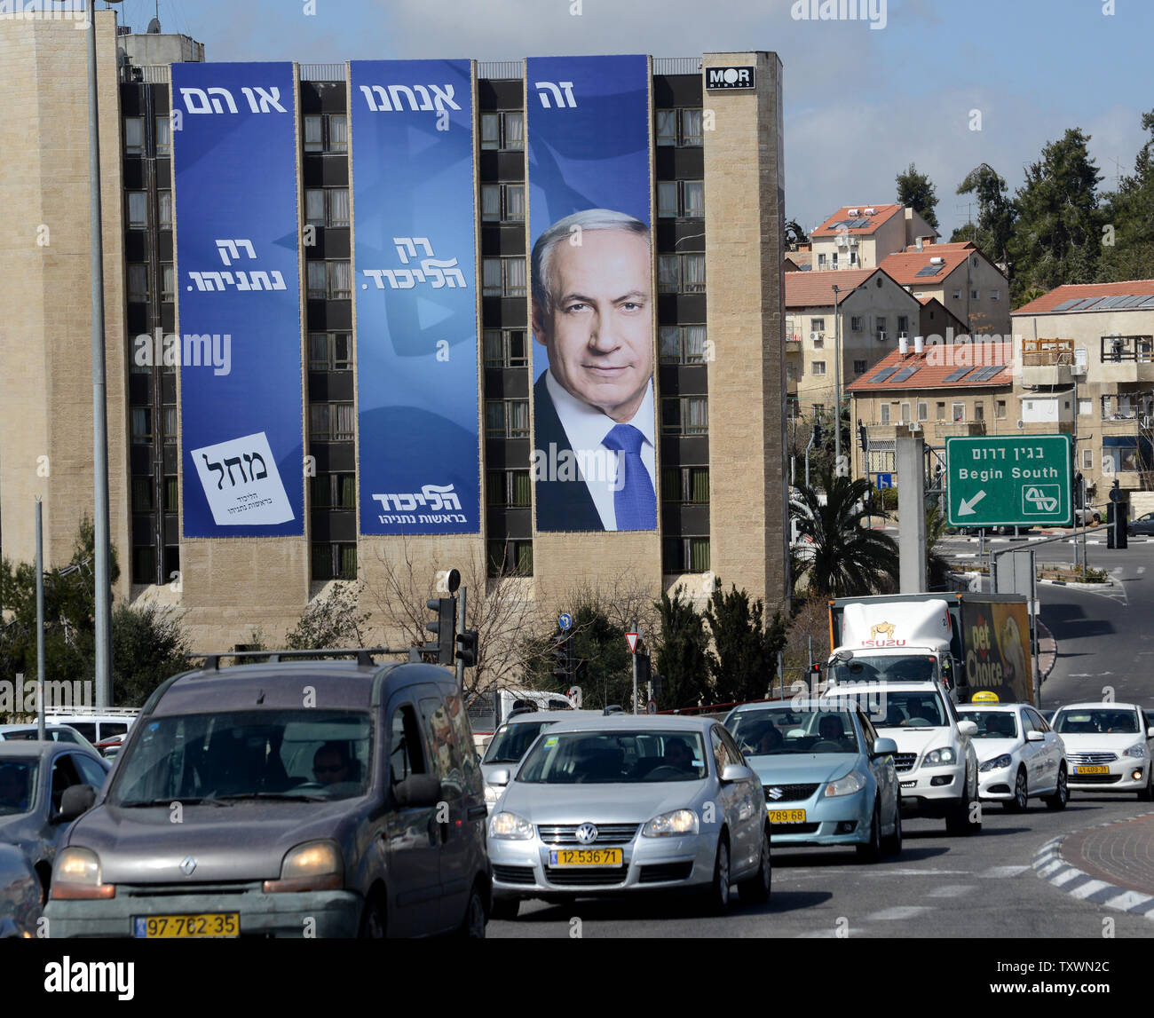 Cars drive past a large campaign poster of Israeli Prime Minister ...