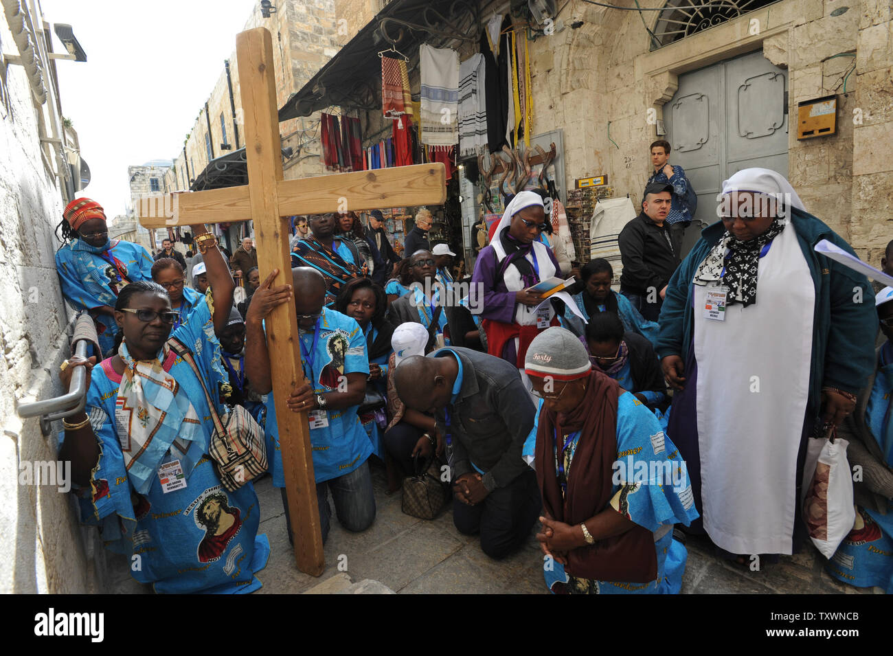 Christian pilgrims kneel and pray with a cross on Good Friday on the ...