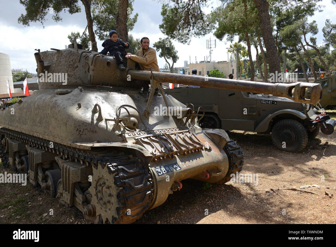 An Israeli man and his son sit on top of a Sherman tank at an Israeli ...