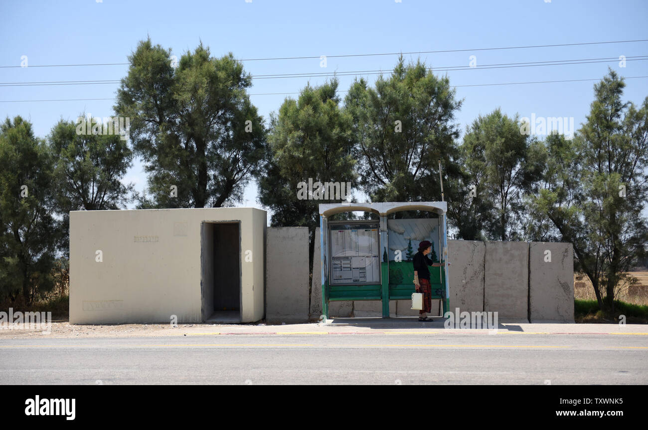 An Israeli woman waits for a bus in a station beside a bomb shelter and ...