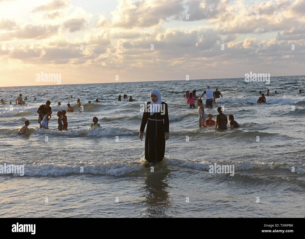 A Muslim Palestinian walks in the Mediterranean Sea in Tel Aviv, Israel ...