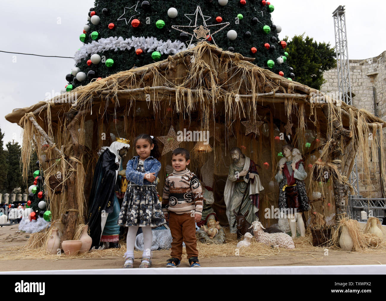 Palestinian children pose for a photo in front of a Nativity Scene in ...