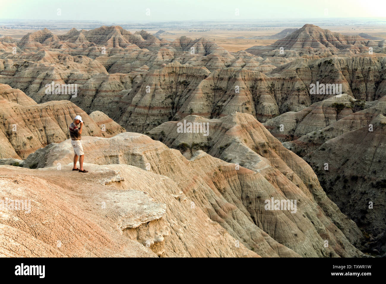 Man with binoculars examines the amazing canyons, spires, valleys ...