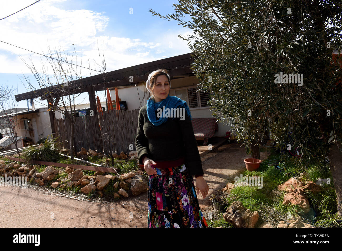 An Israeli settler stands outside her house in the Israeli illegal ...