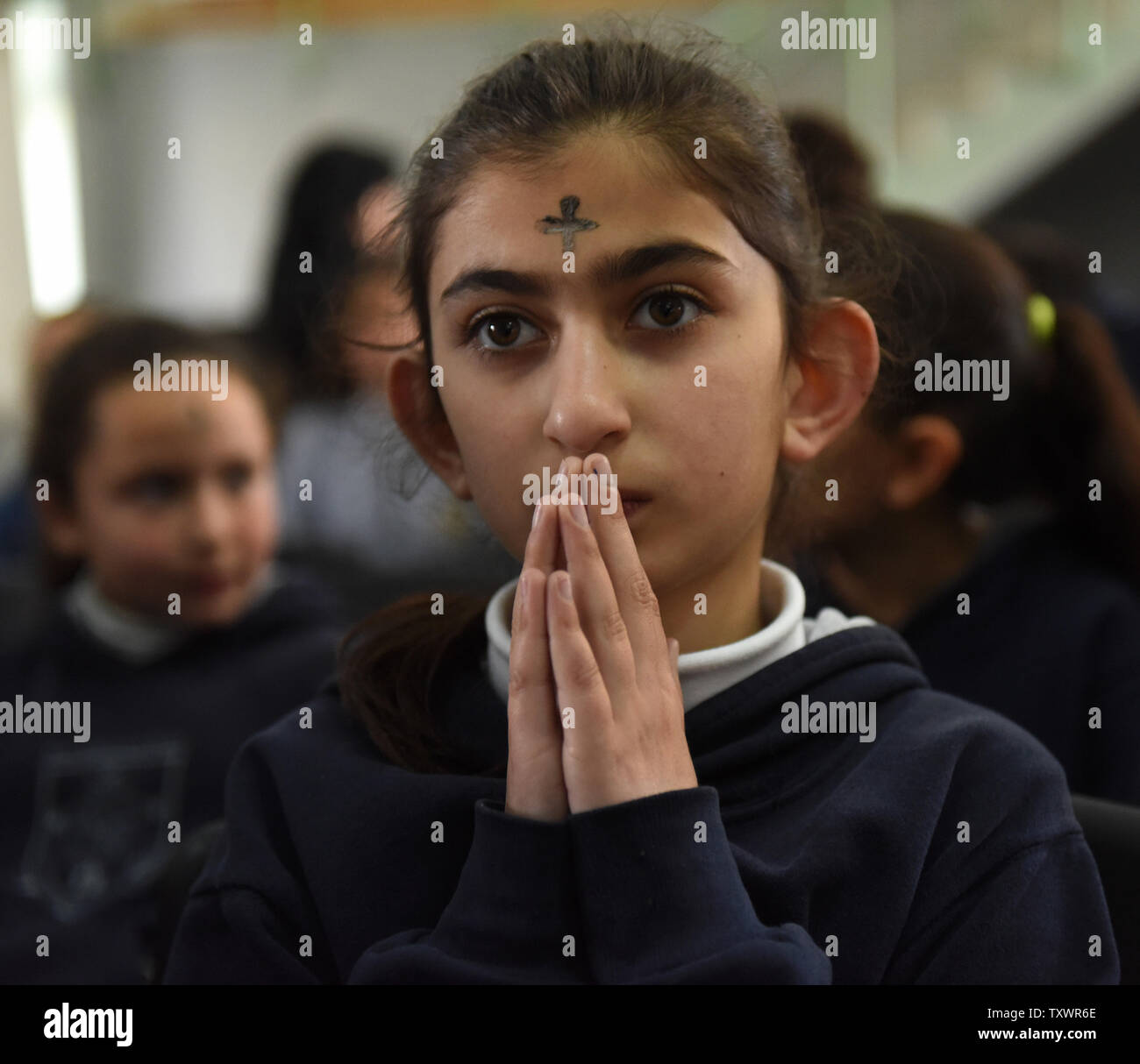 A Palestinian Catholic girl prays during mass on Ash Wednesday in the ...