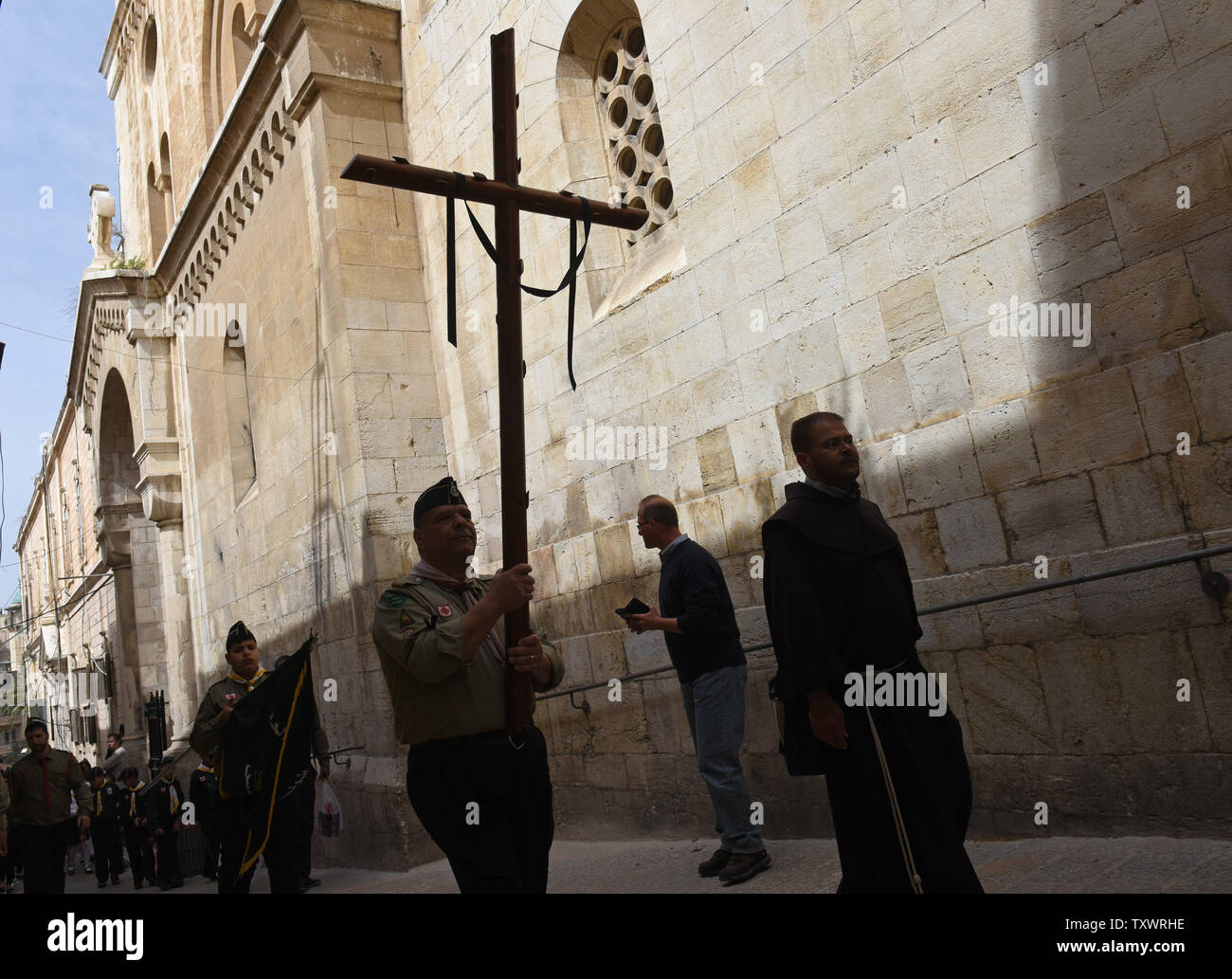 A Palestinian scout carries a large cross on Good Friday on the Via ...