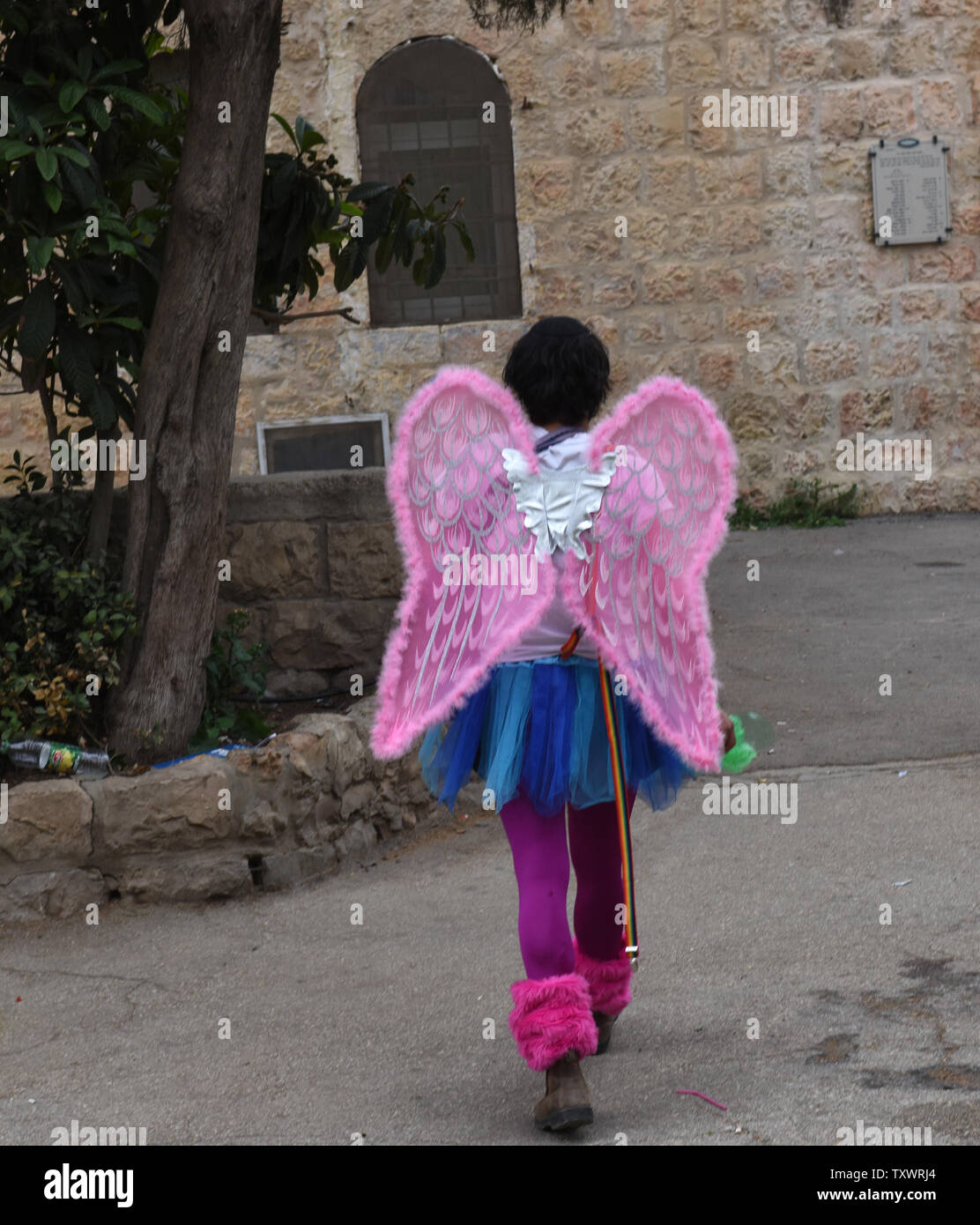 An Israeli wears an angel costume to celebrate the Jewish holiday of ...