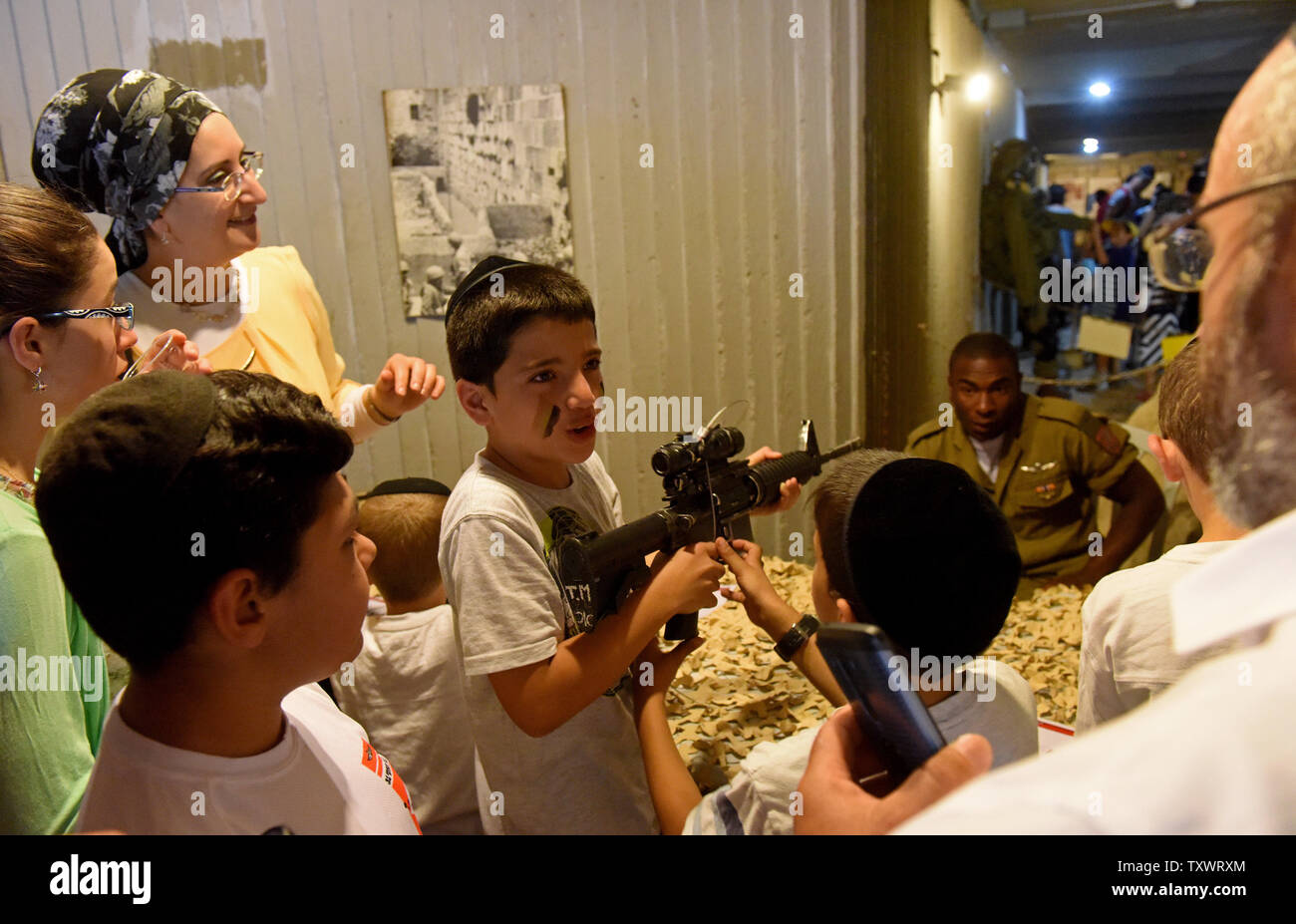 An Israeli boy holds an automatic weapon at a military exhibition on ...