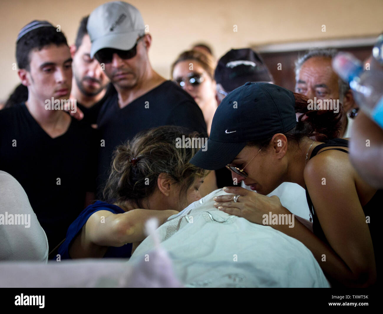 Family and friends mourn by the body of Ido Ben Ari, 42, during his funeral in Yavneh, Israel ...
