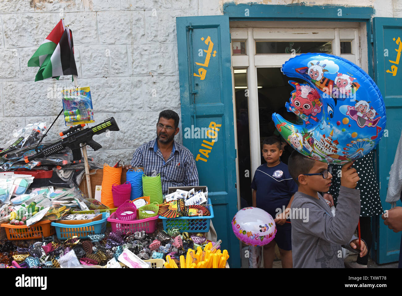A boy holds a balloon for the Muslim festival of Eid al-Fitr in the ...