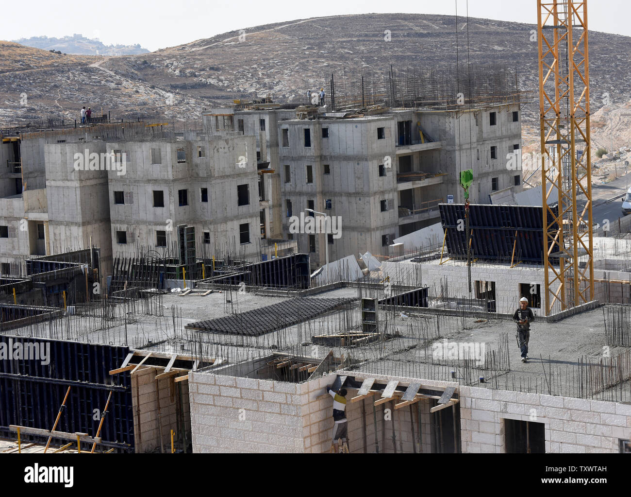 A construction worker stands on the roof of new housing units under ...