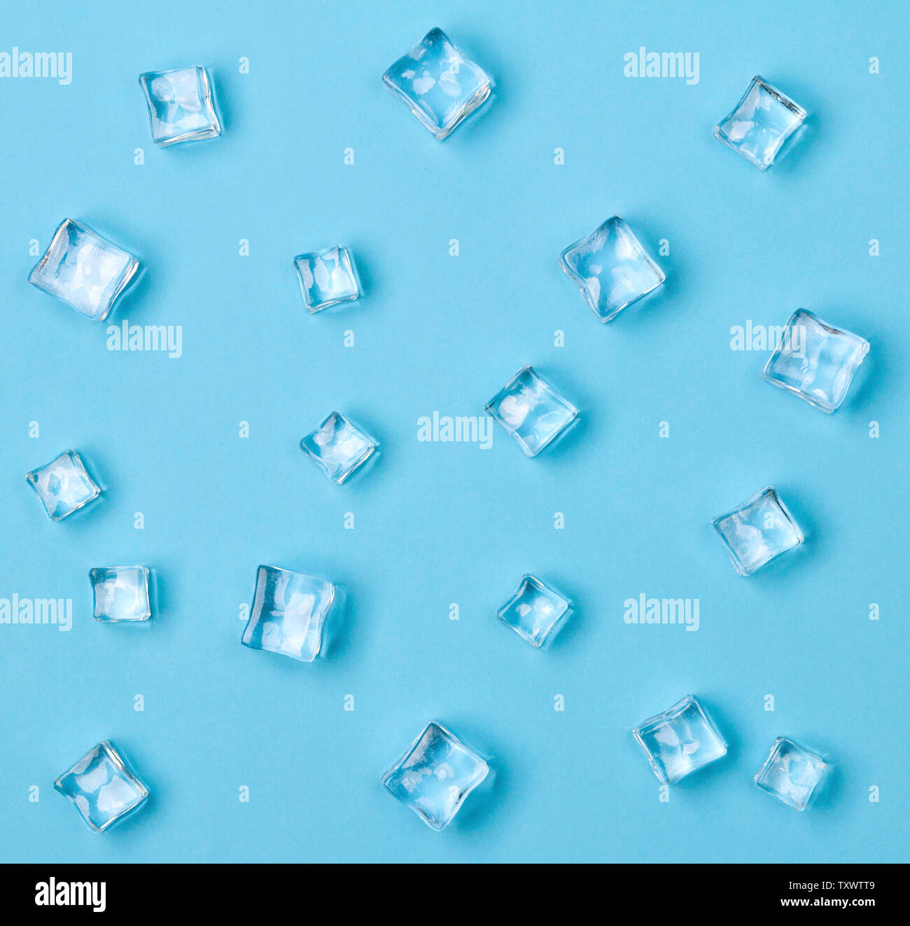 Ice cubes scattered on a light blue background Stock Photo - Alamy