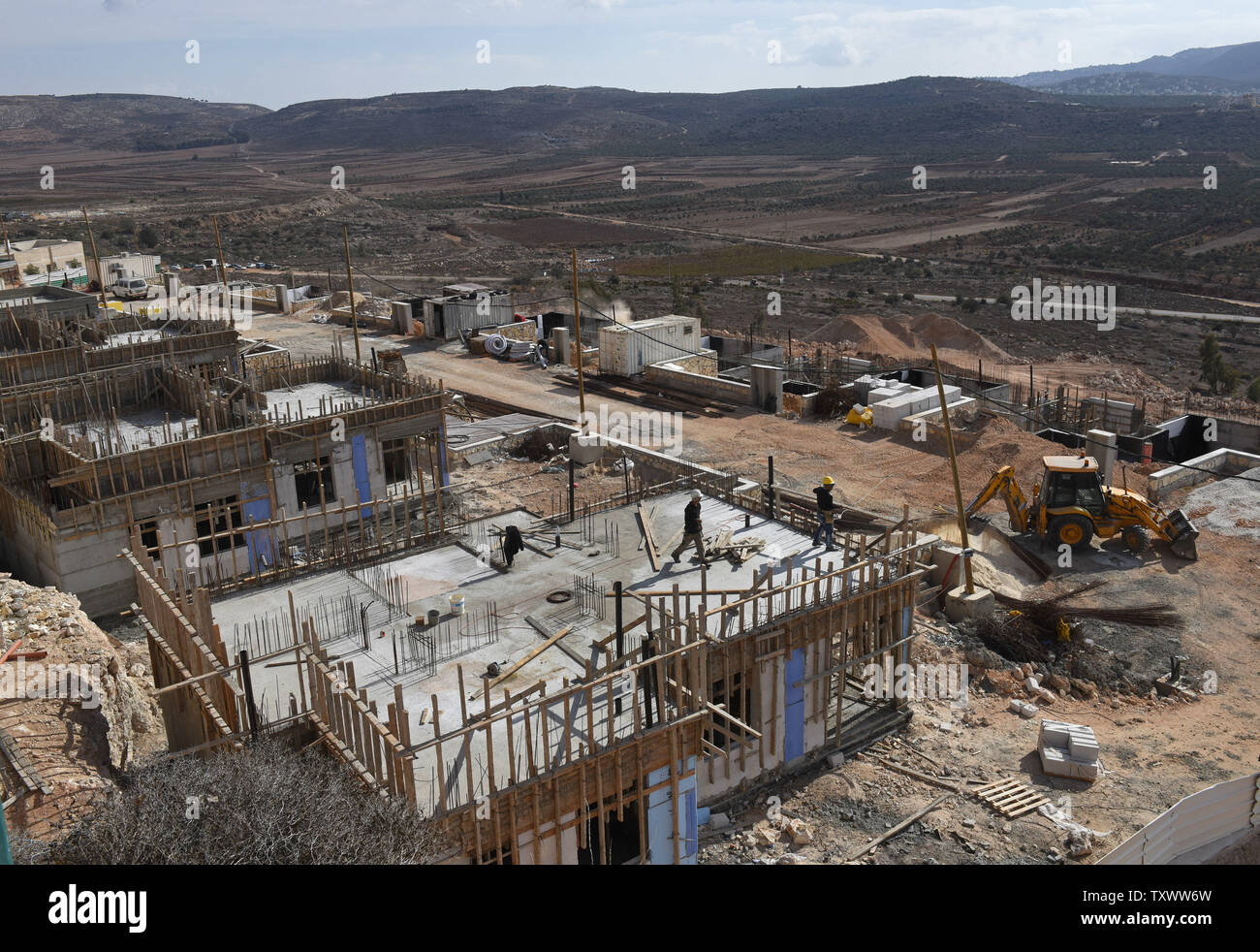 Construction workers build new Jewish homes in the Israeli settlement ...