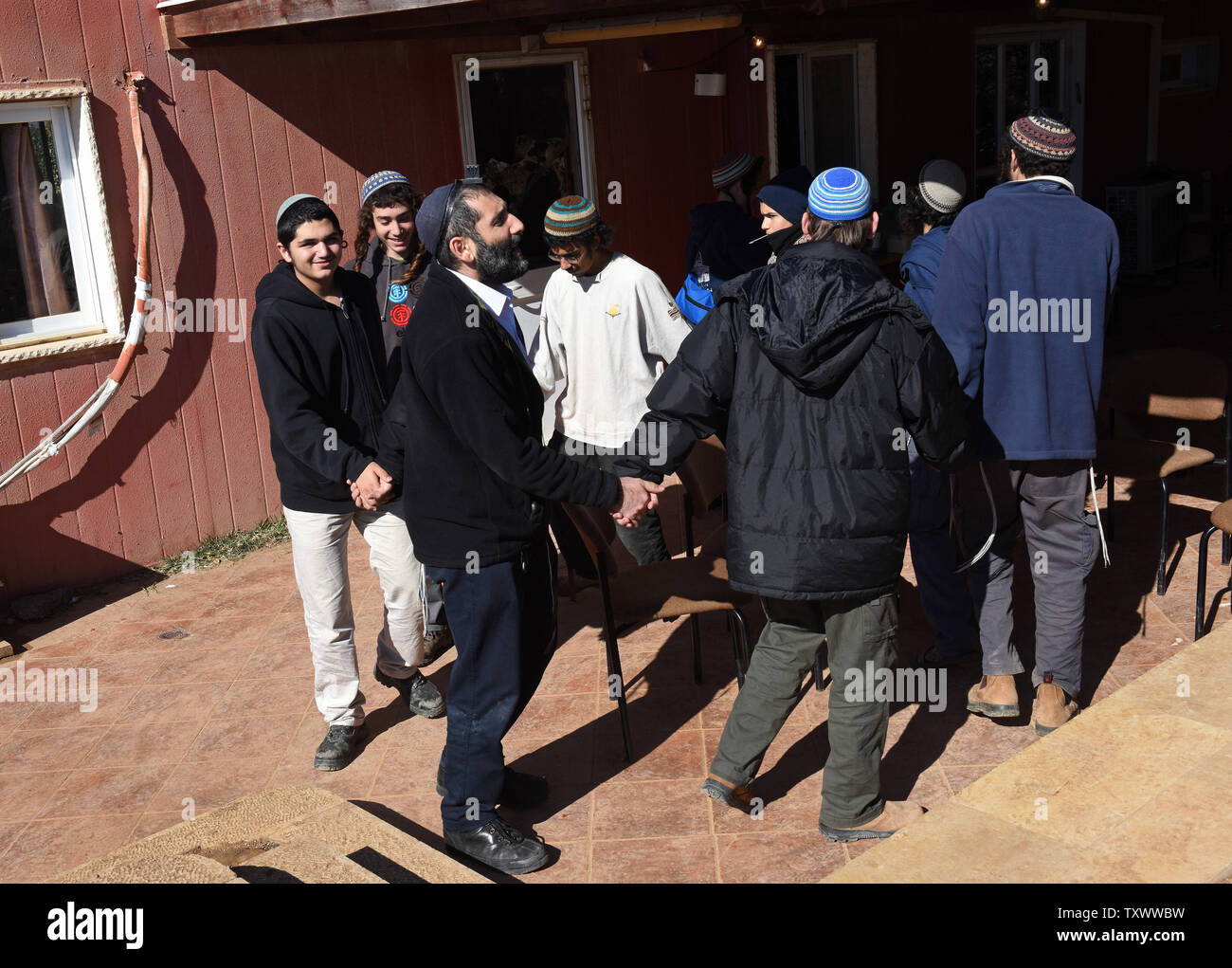 Jewish settlers dance outside the synagogue in the unauthorized Israeli ...
