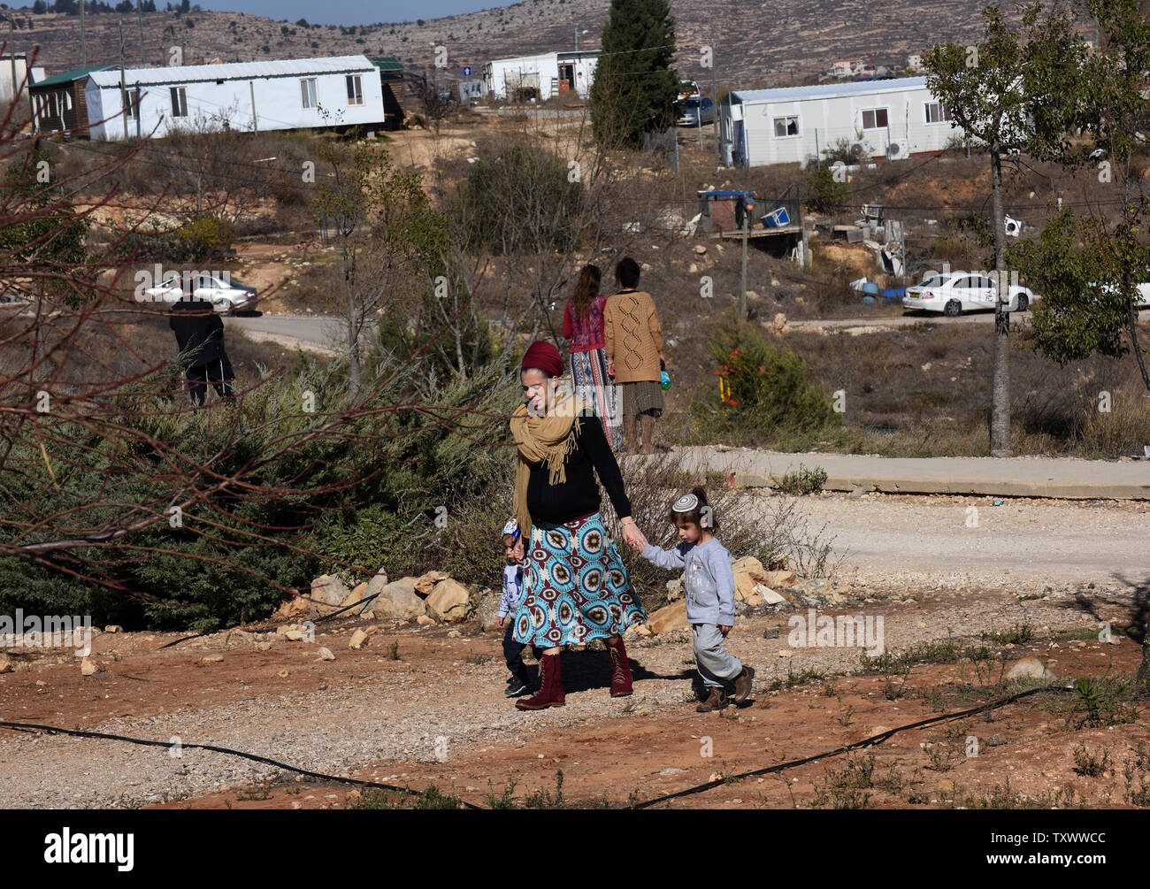 A Jewish settler walks with her son in the unauthorized Israeli ...